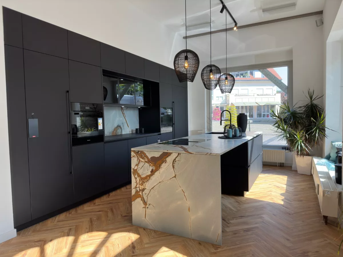 Eine grifflose Küche mit Natursteinarbeitsplatte