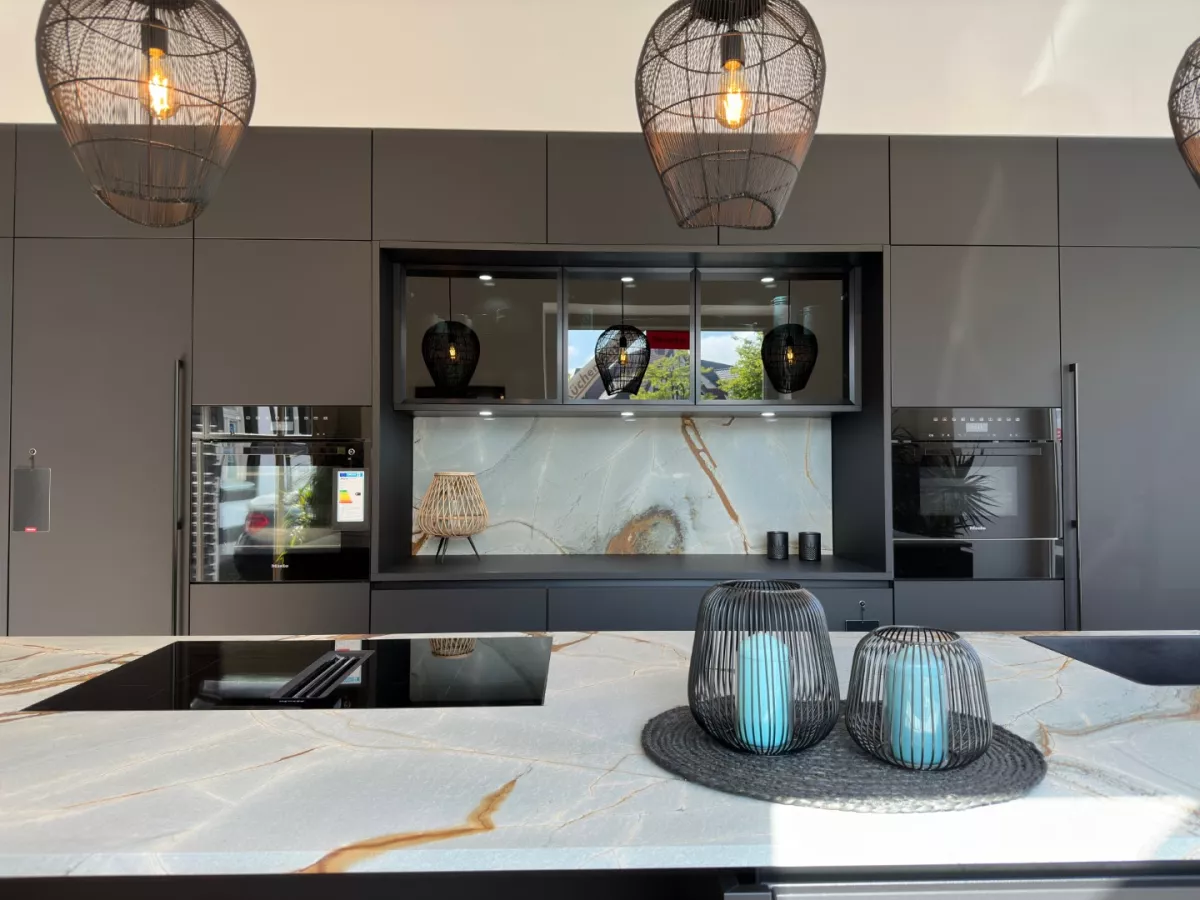 Eine grifflose Küche mit Natursteinarbeitsplatte